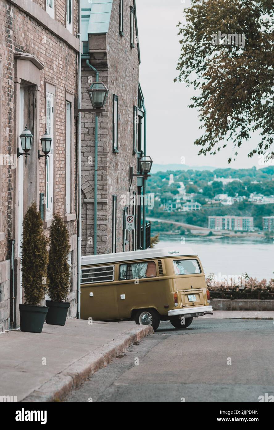 A vertical shot of an old, yellow van on the street in Quebec, Canada ...