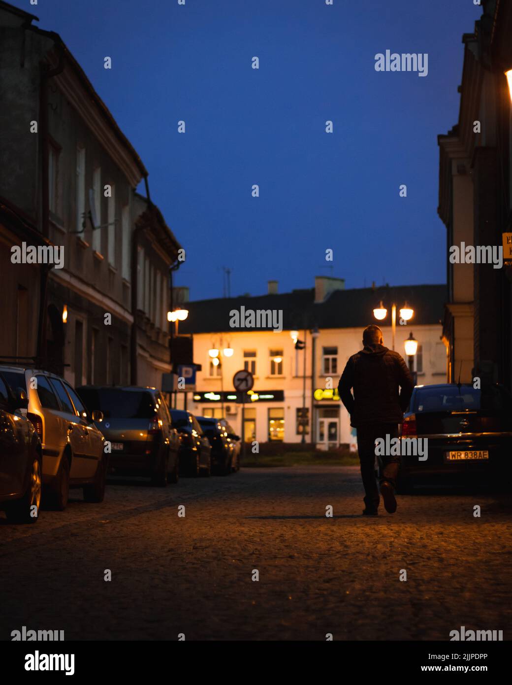 A beautiful Man walking through an empty street with a tiled floor at ...