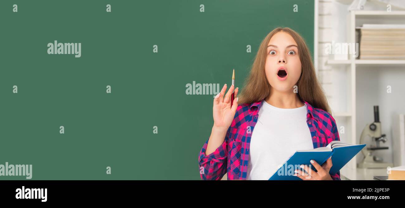 amazed child study at school with book on blackboard background ...