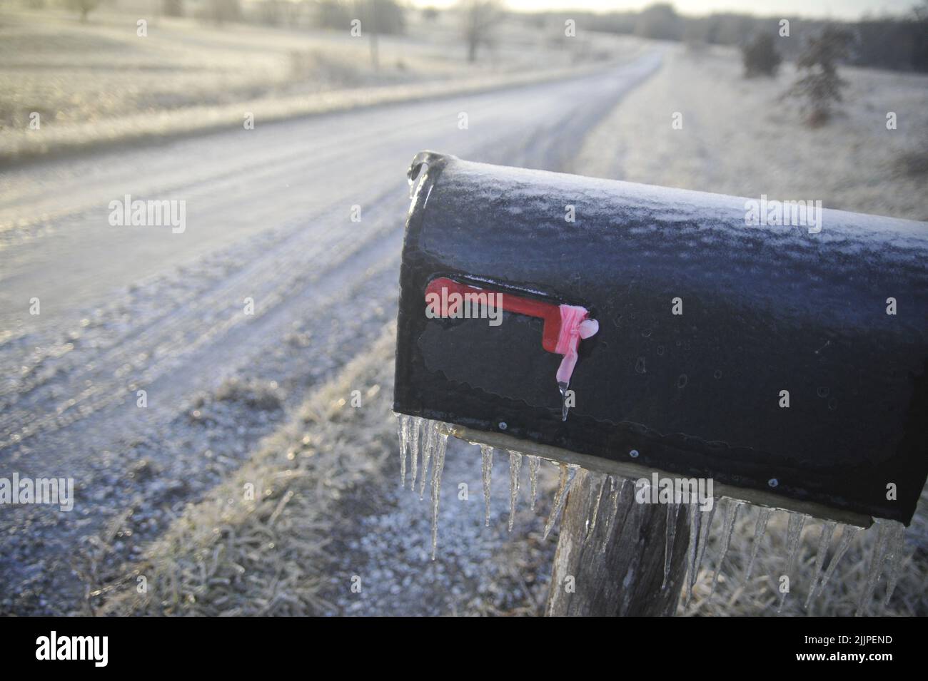 A shallow focus of a mailbox covered with melting ice from a winter ...