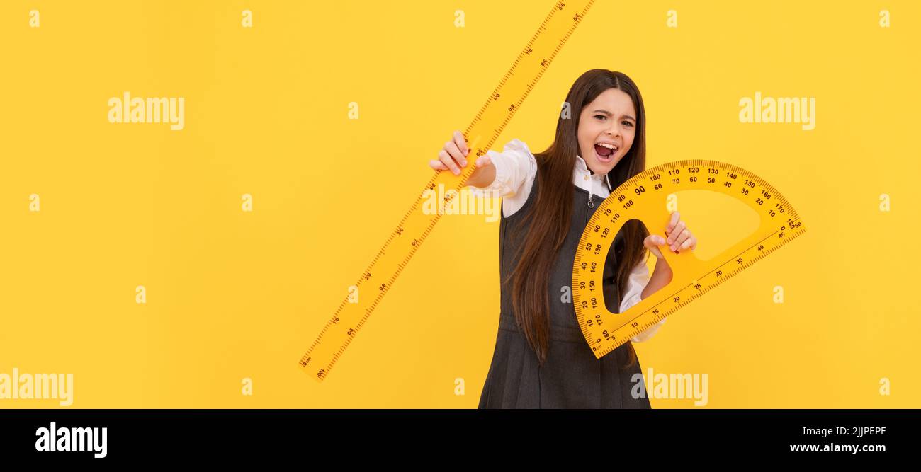 emotional child hold math protractor and ruler in school on yellow ...