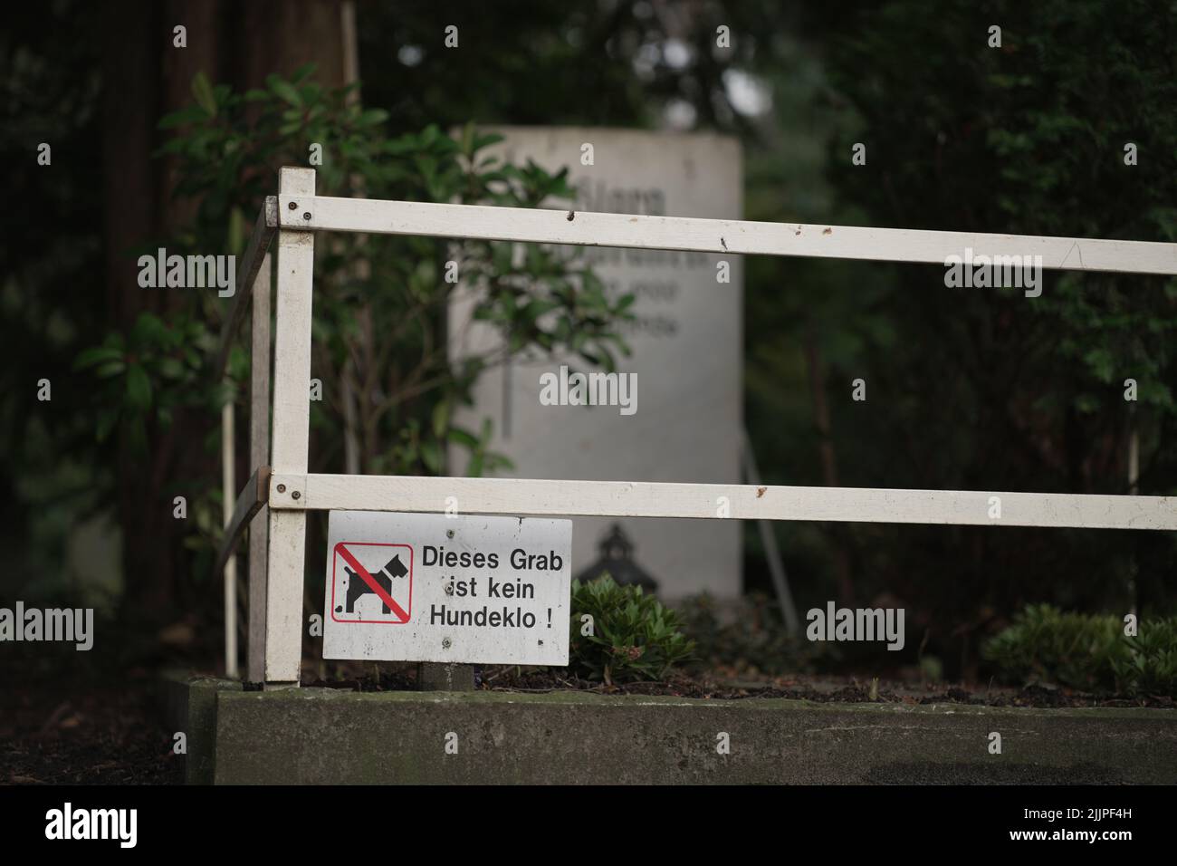 A grave with a sign that says in German: this grave is not a dog toilet ...