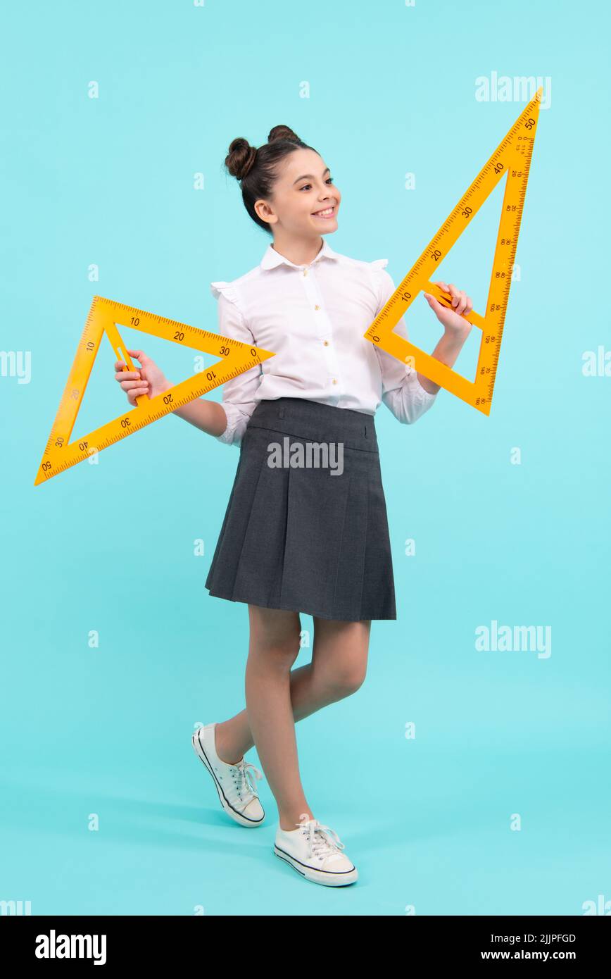 School girl holding measure for geometry lesson, isolated on blue ...