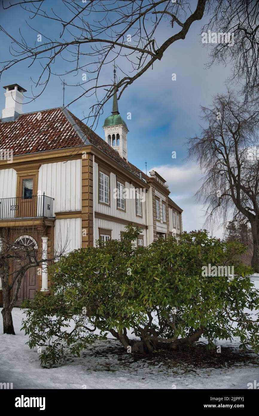 The exterior design of Leangen gaard house with trees in snowy day in ...