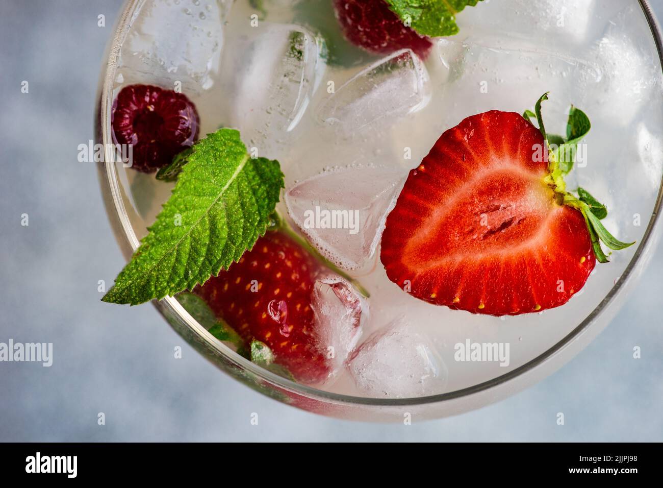 Overhead view of a summer cocktail with fresh raspberries and ...