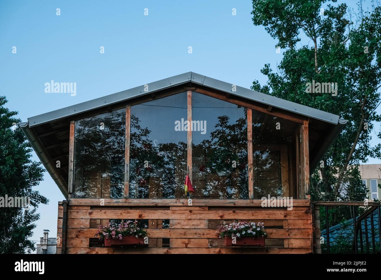 A low angle shot of a wooden house facade with large glass mansard ...