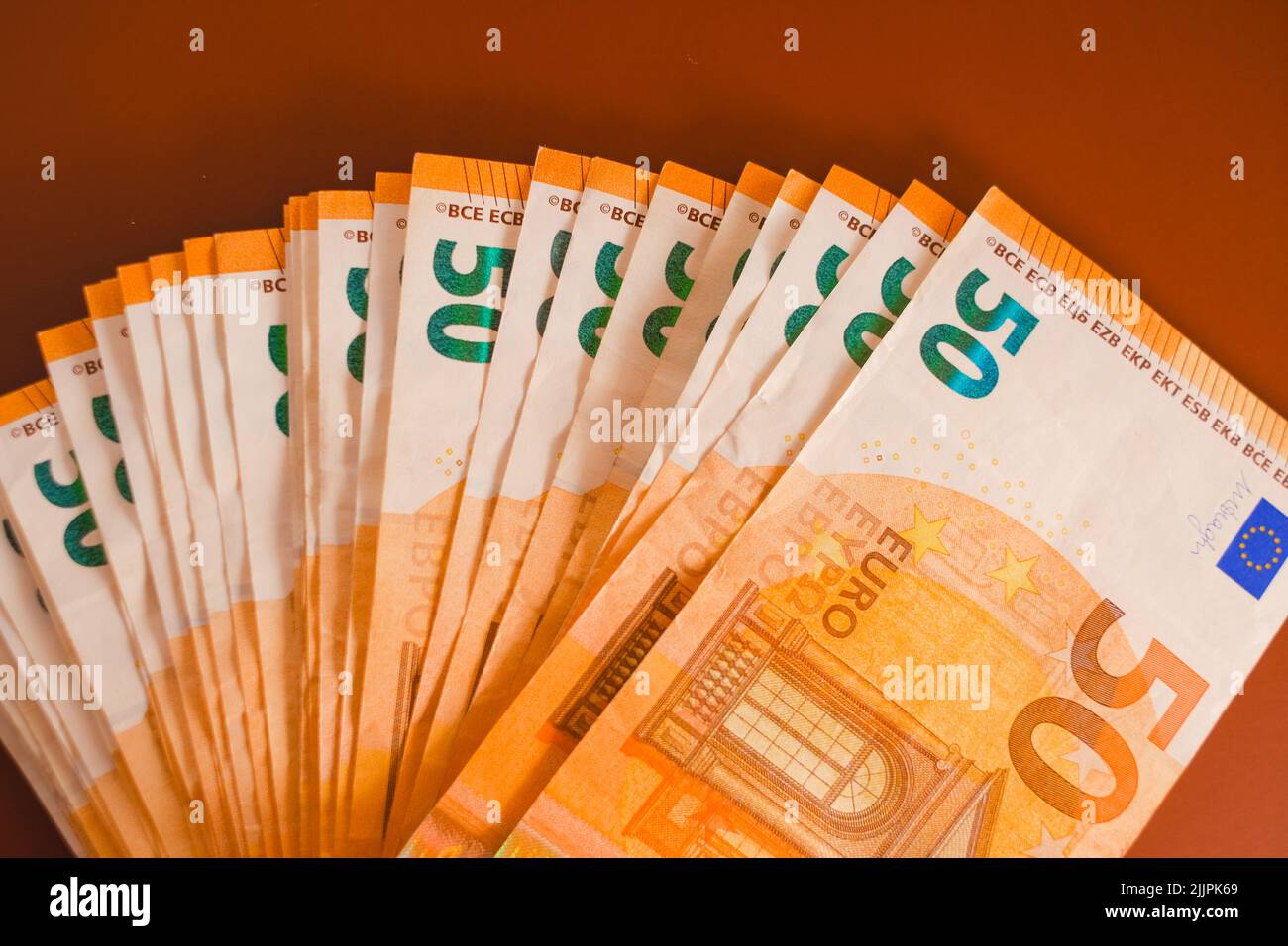 Money background.fifty euros banknotes set on a burgundy background ...