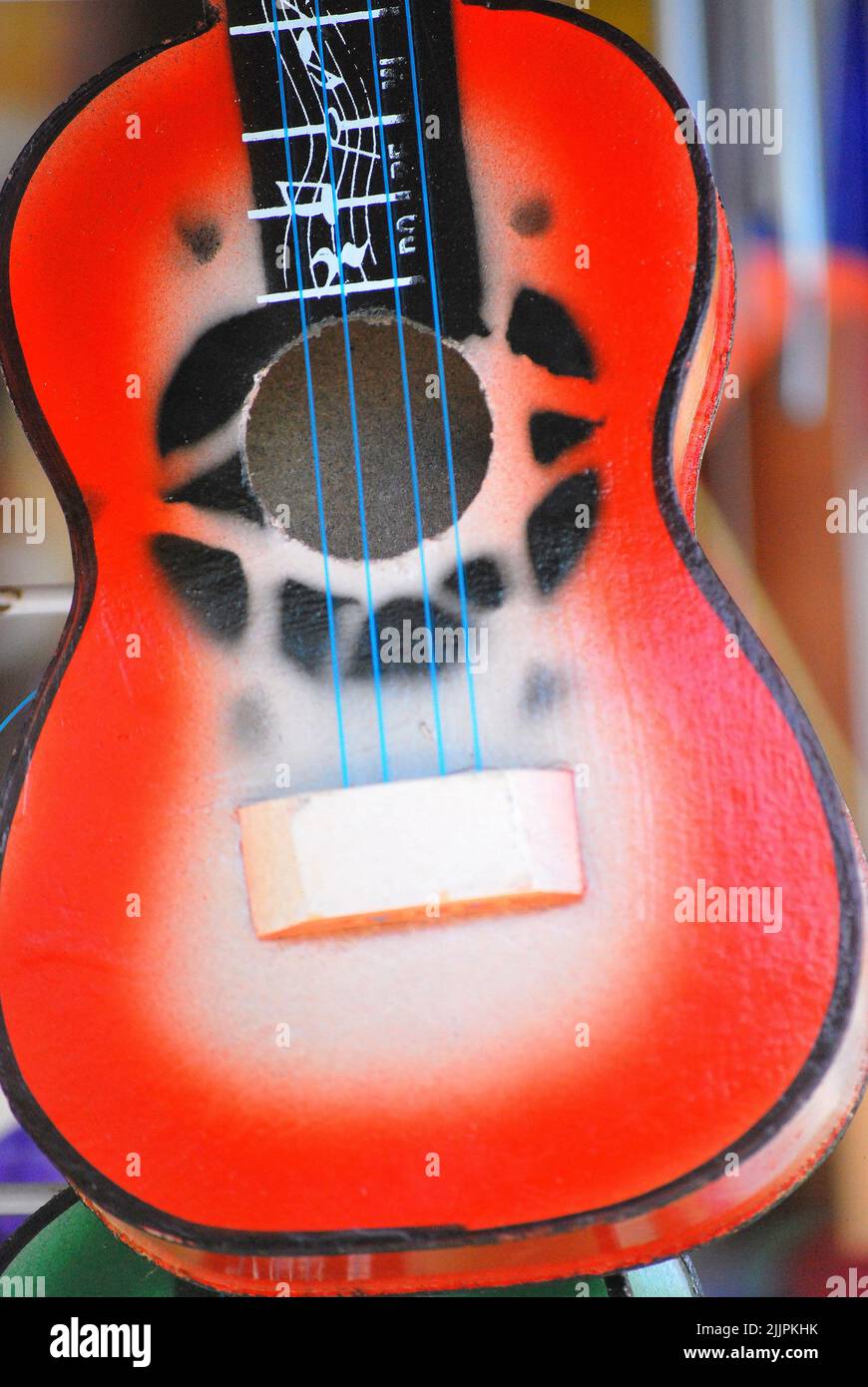 A vertical closeup of a red Mexican guitar with black patterns Stock ...