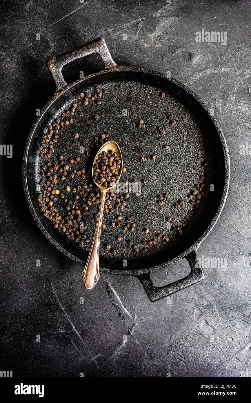 Overhead view of black peppercorns in a metal frying pan Stock Photo ...