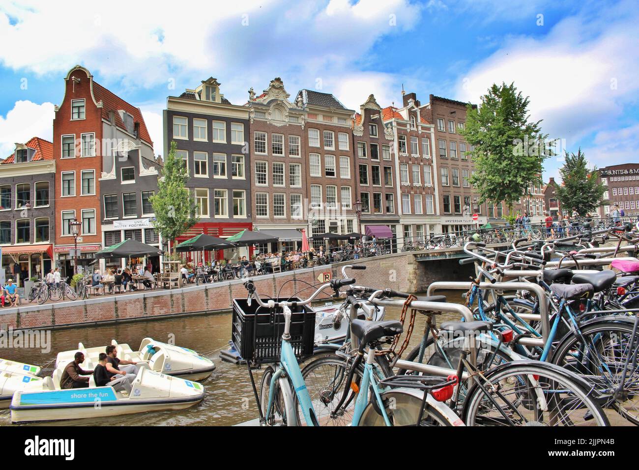 A row of historical buildings lining a canal at the city of Amsterdam ...