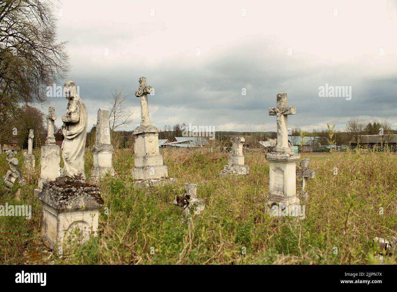 An old cemetery with gravestones under a cloudy sky Stock Photo - Alamy
