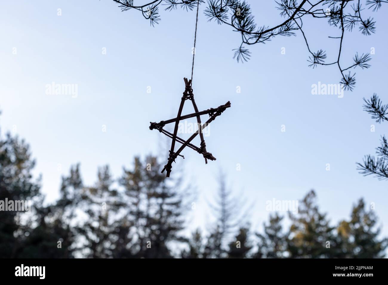 A closeup shot of a wooden star hung on the tree Stock Photo - Alamy