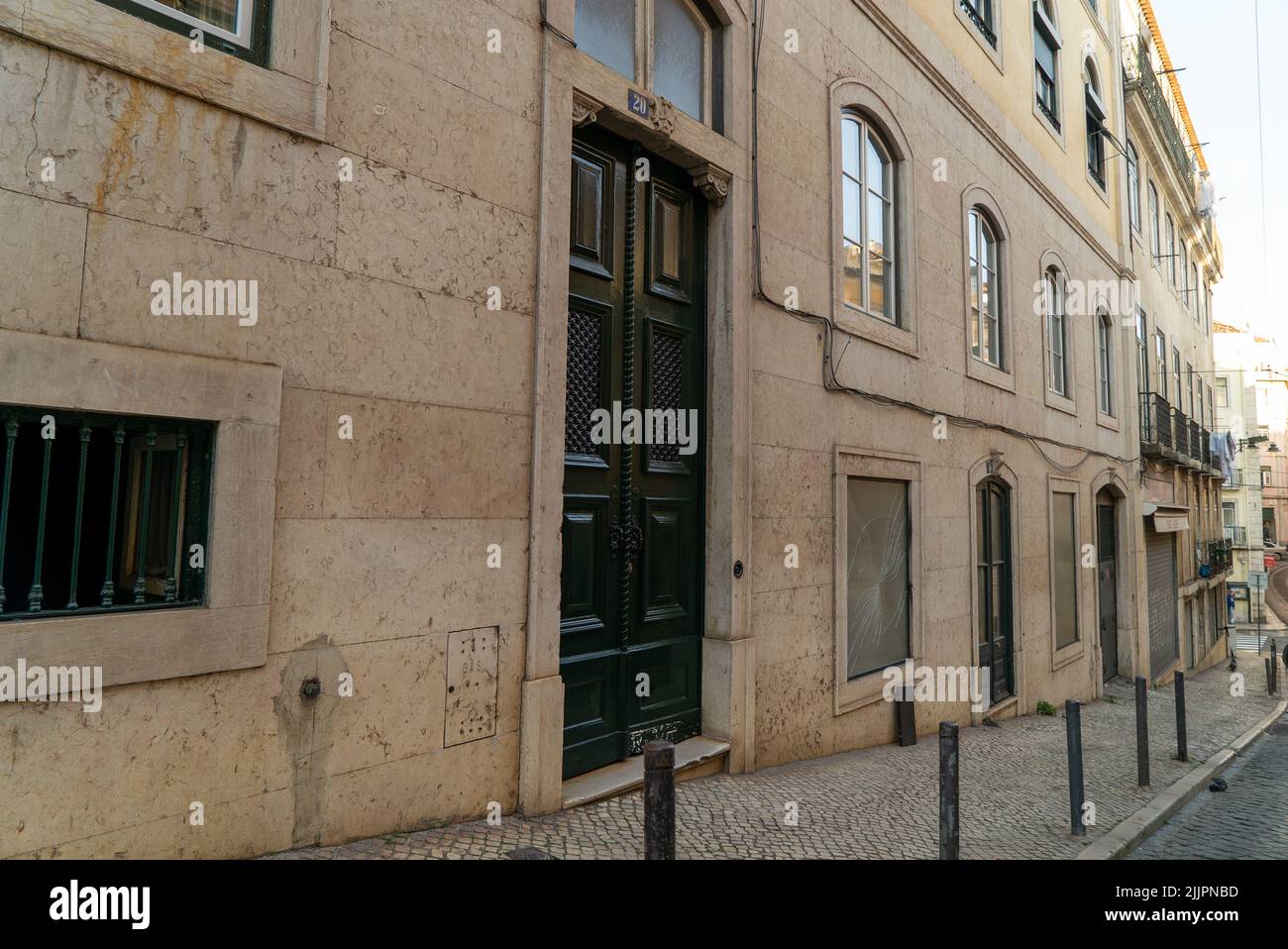 A shot of an old-style dark door of a building with arcade windows ...