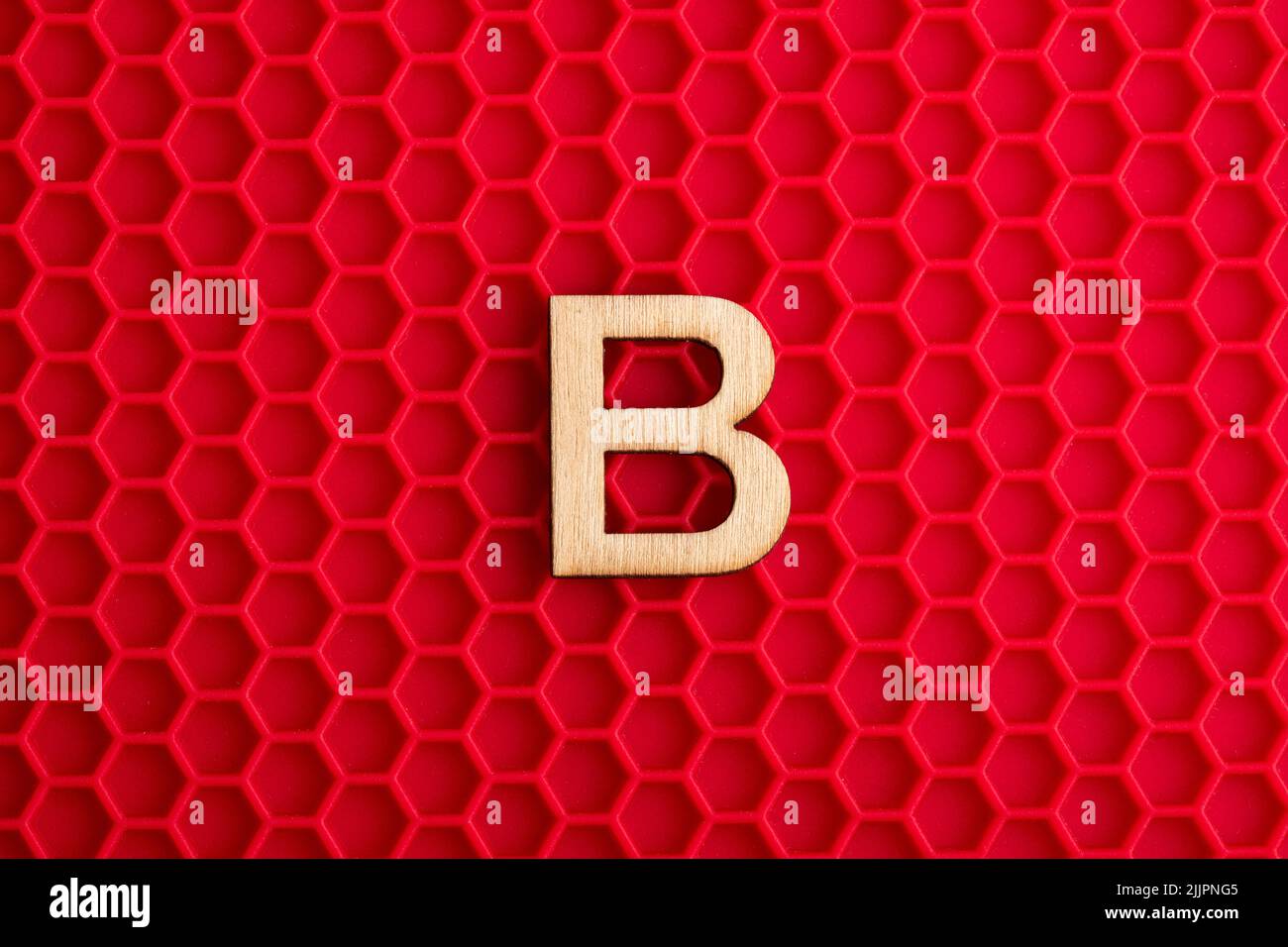 Capital letter B - White piece on silicone background with red hexagons ...