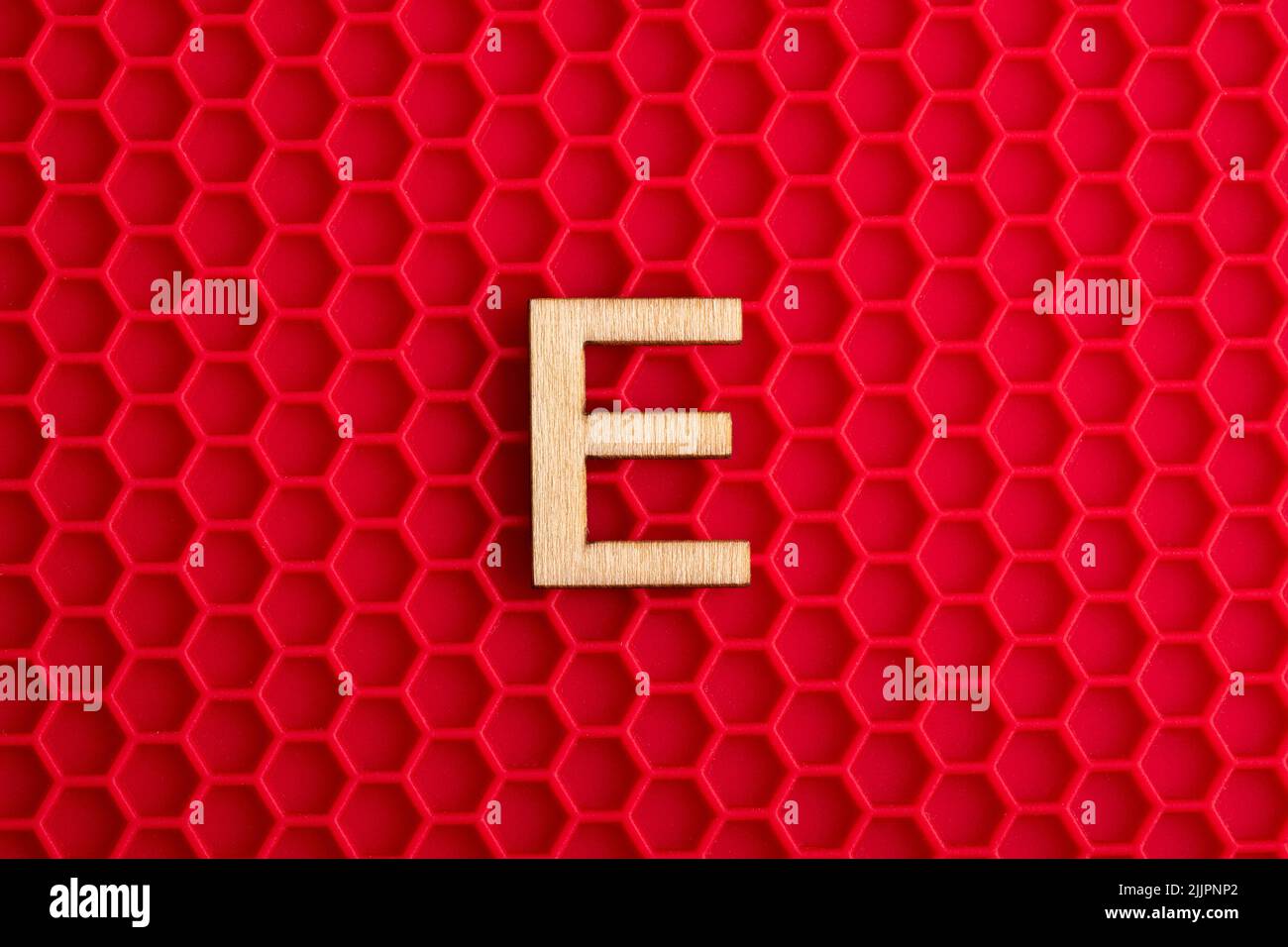 Alphabet letter E - White piece on silicone background with red ...