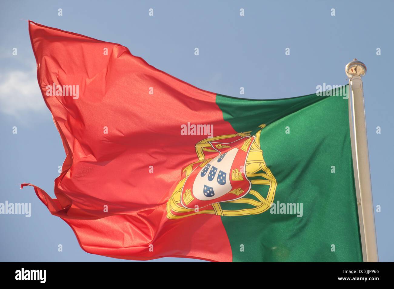 Portugal national flag against blue cloudy sky Stock Photo - Alamy