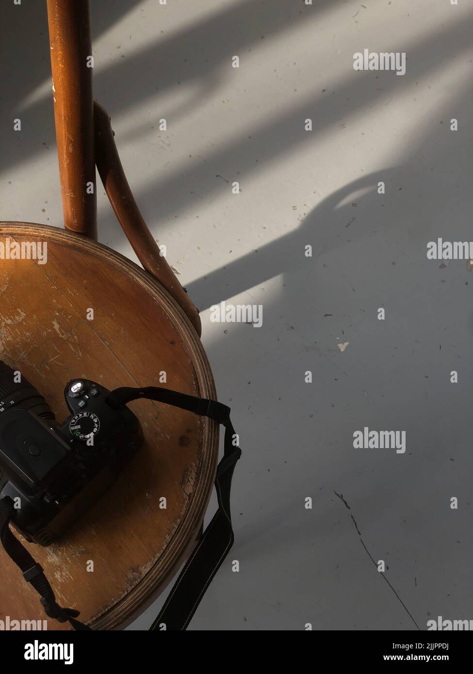 A top view of a black camera on a round vintage wooden chair with a ...
