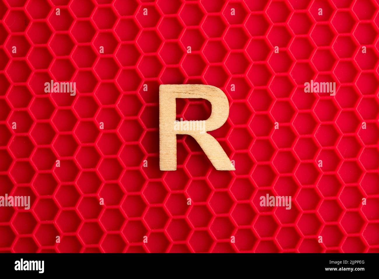 Capital Letter R White Piece On Silicone Background With Red Hexagons