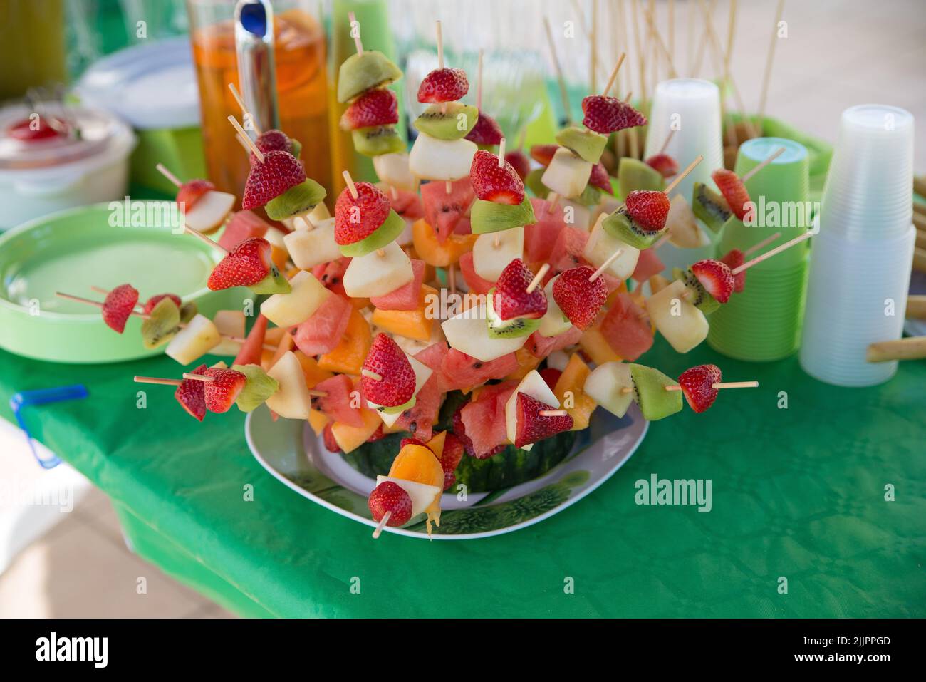 A selective focus shot of sliced fruit on sticks on a festive table ...
