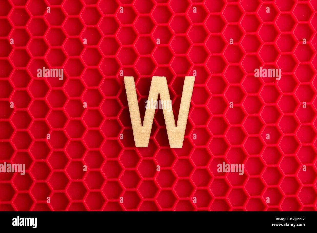 Alphabet letter W - White piece on silicone background with red ...