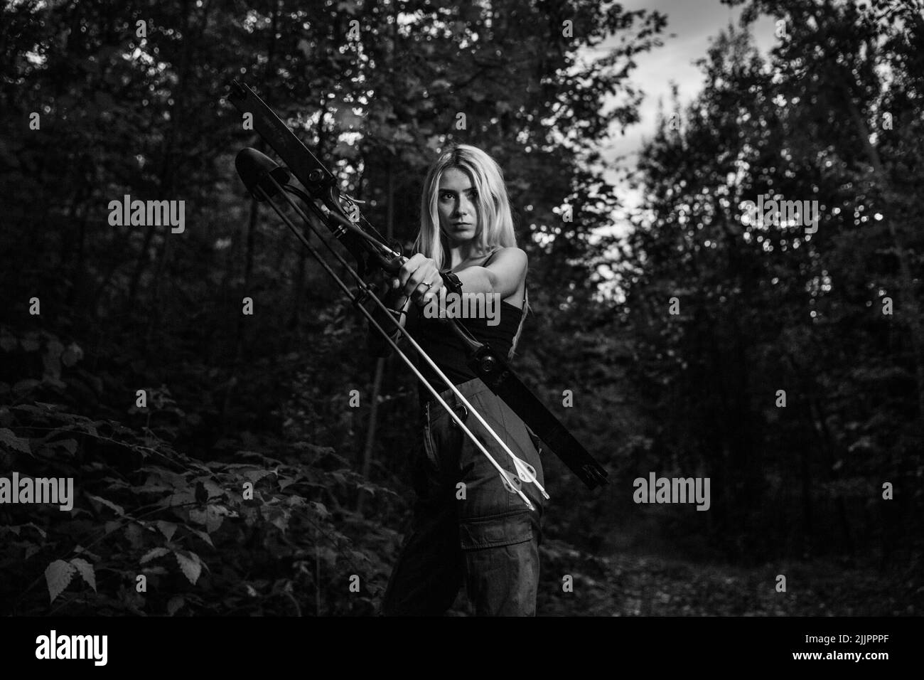 A grayscale portrait of a Caucasian blond female holding arrow and ...