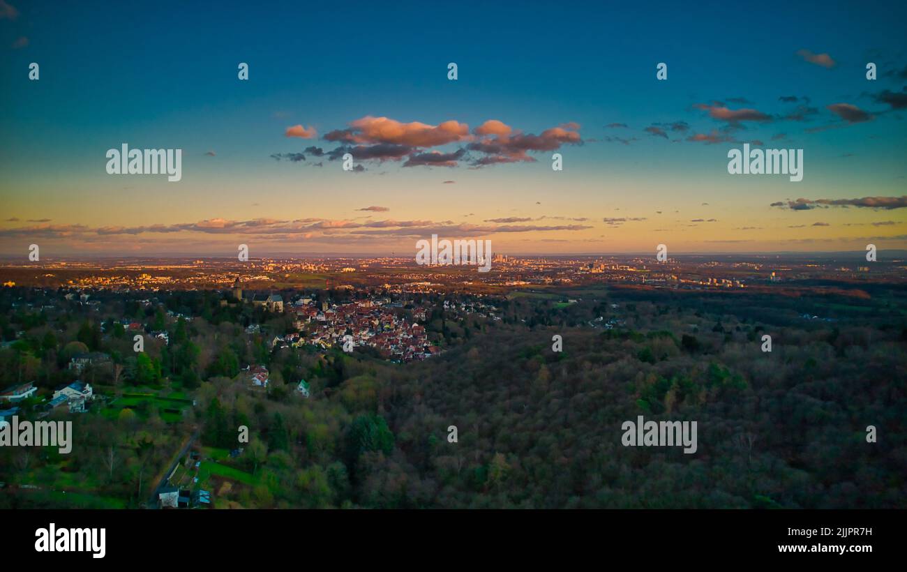 An aerial view of a rural area surrounded by lush green forests against ...