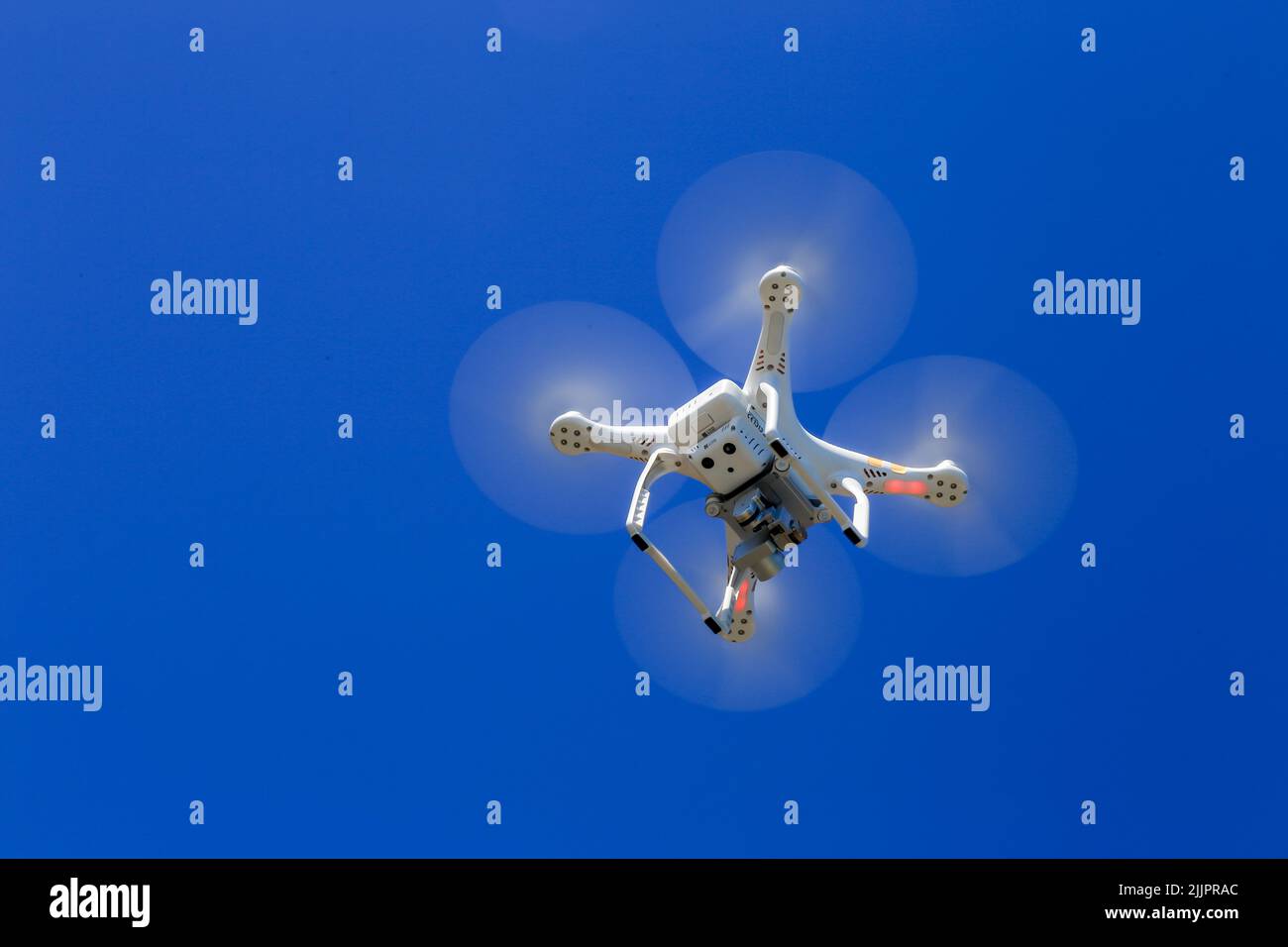 A low angle shot of a DJI drone flying in the blue sky Stock Photo - Alamy