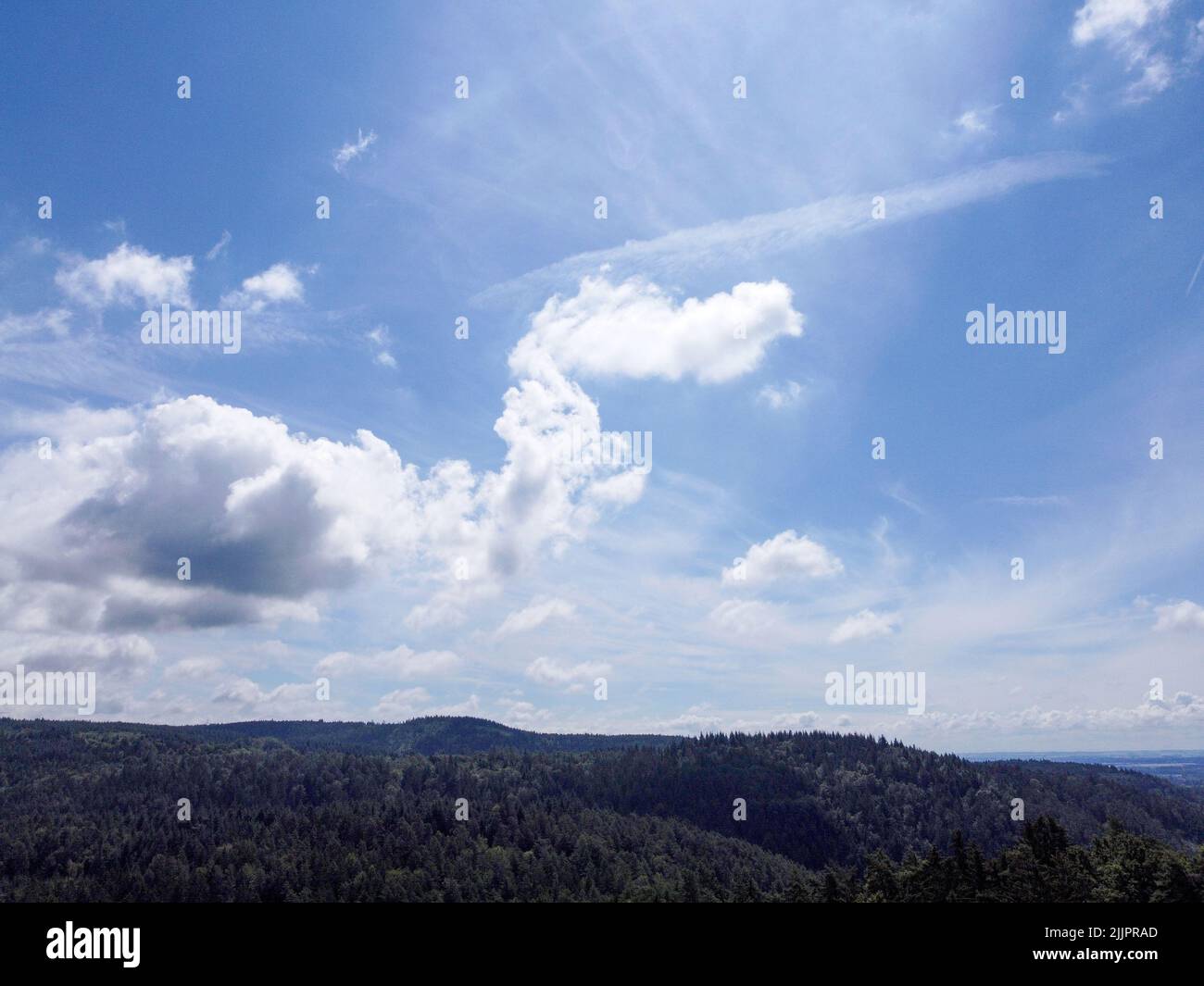 A picturesque view of mountain forests on a blue cloudy sky background ...