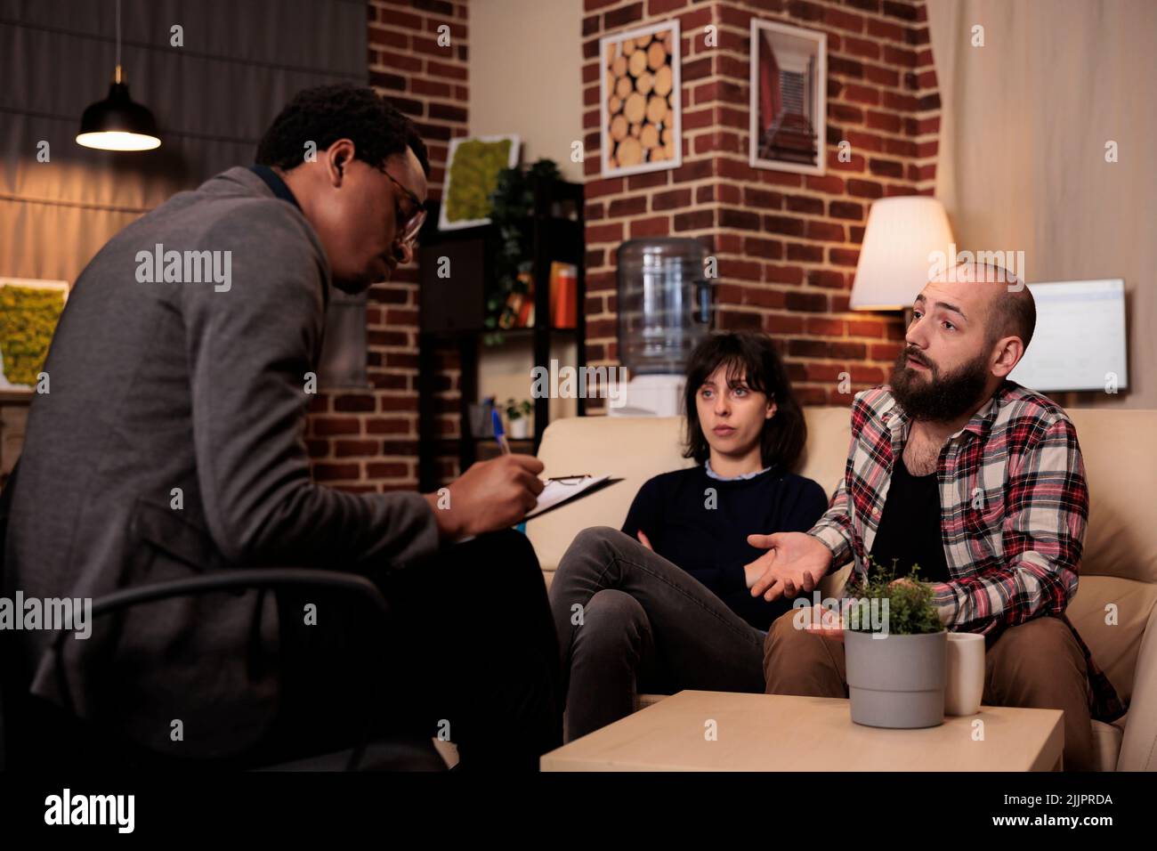 Husband and wife attending therapy consultation with counselor to solve ...