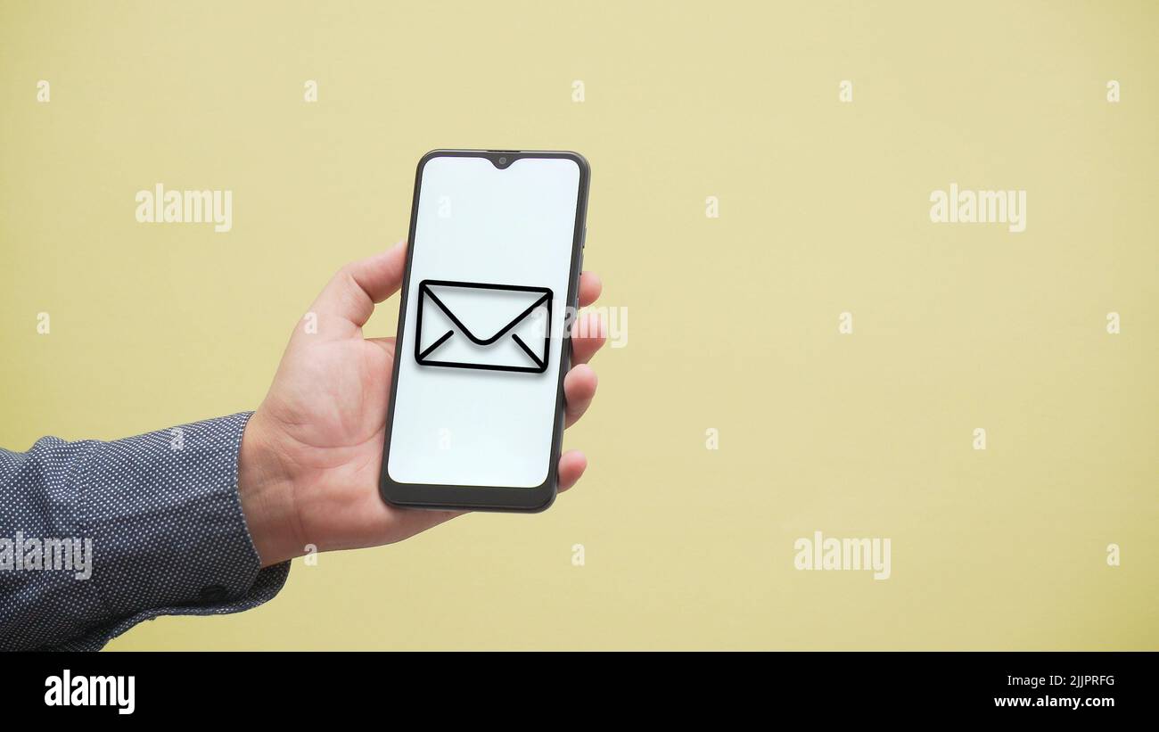 A closeup shot of a hand carrying a mobile phone and messages logo ...