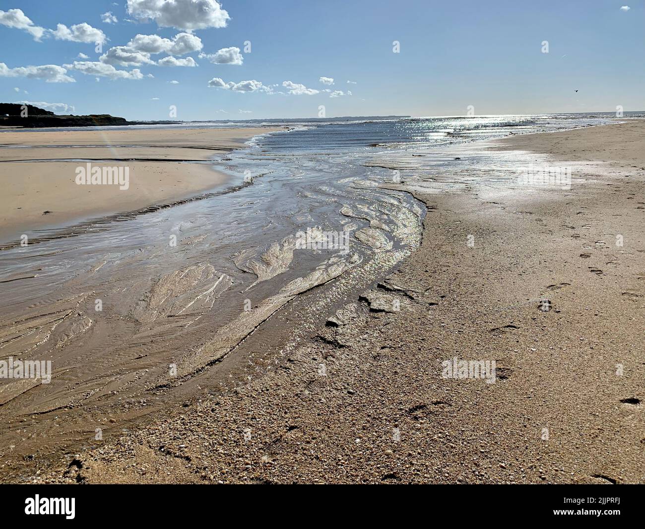 The wet sand at the beach during the daytime Stock Photo - Alamy