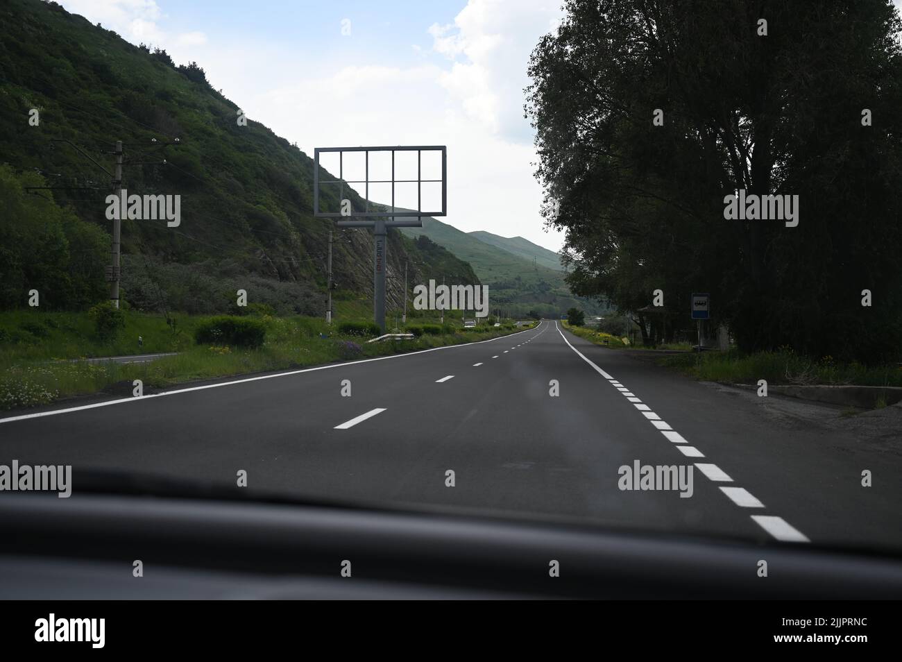 A shot of clean asphalt highway with trees from a car Stock Photo - Alamy