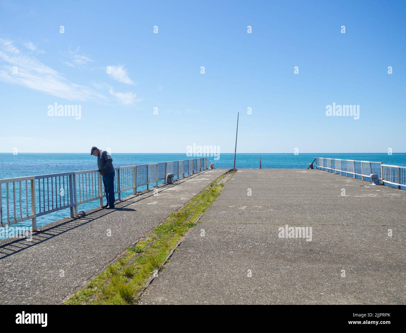 Lonely man on the pier. Rest on the seashore. Escape from everyday life ...