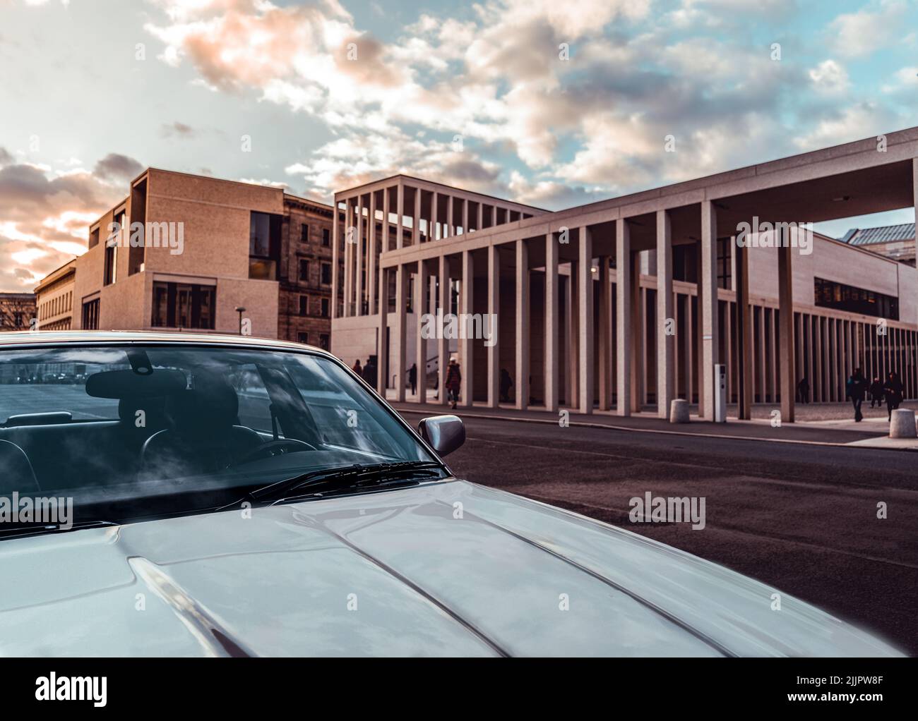 A scenic view of a car parked against a modern building with columns in ...