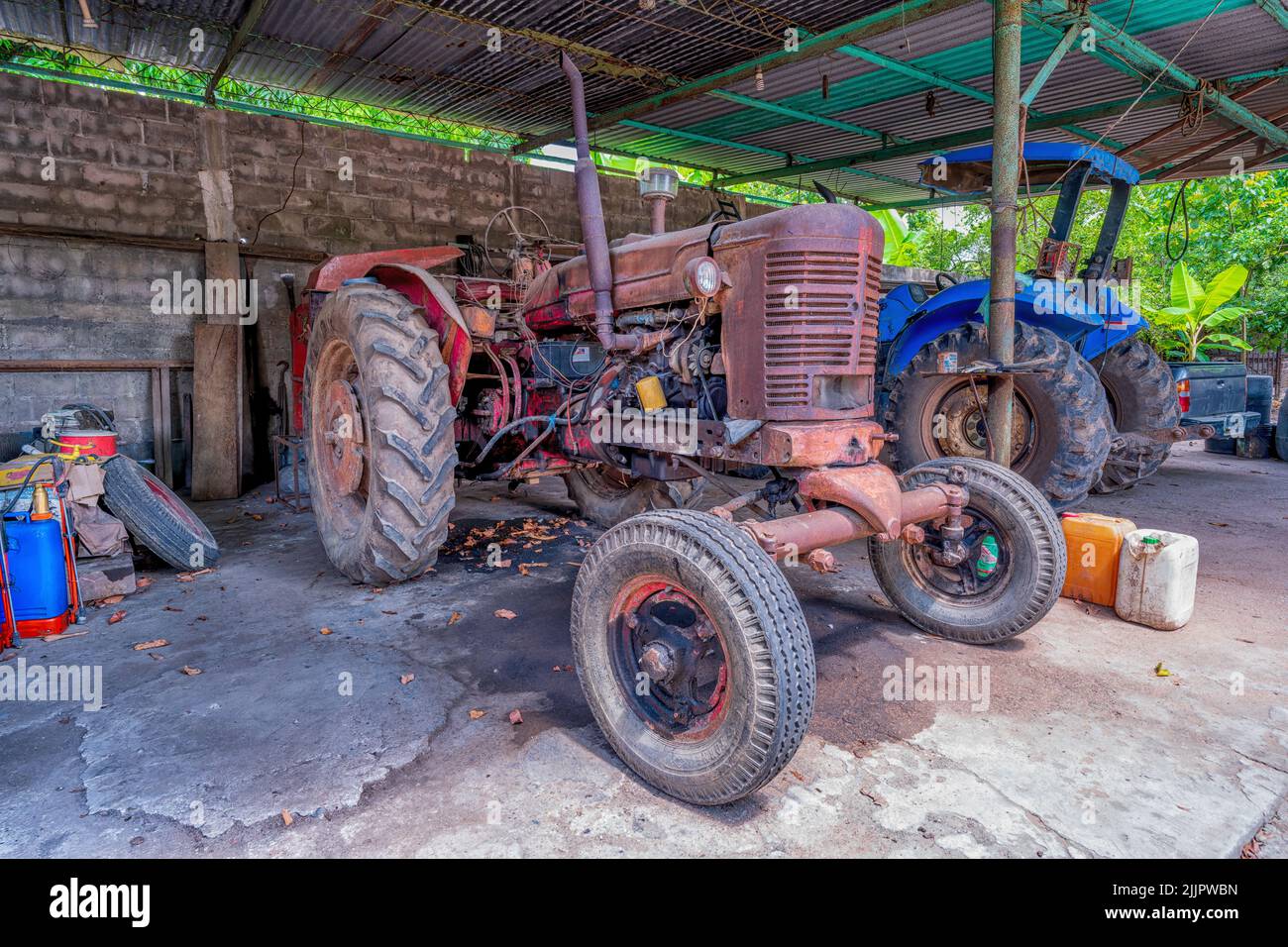 A tractor in a garage in a rural area Stock Photo - Alamy
