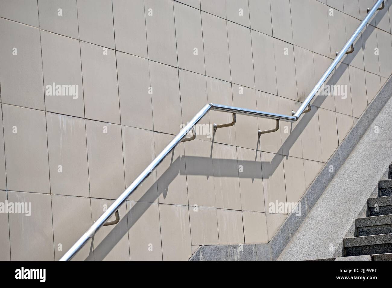 silver metallic zigzag railing on the stone wall, urban travel ...