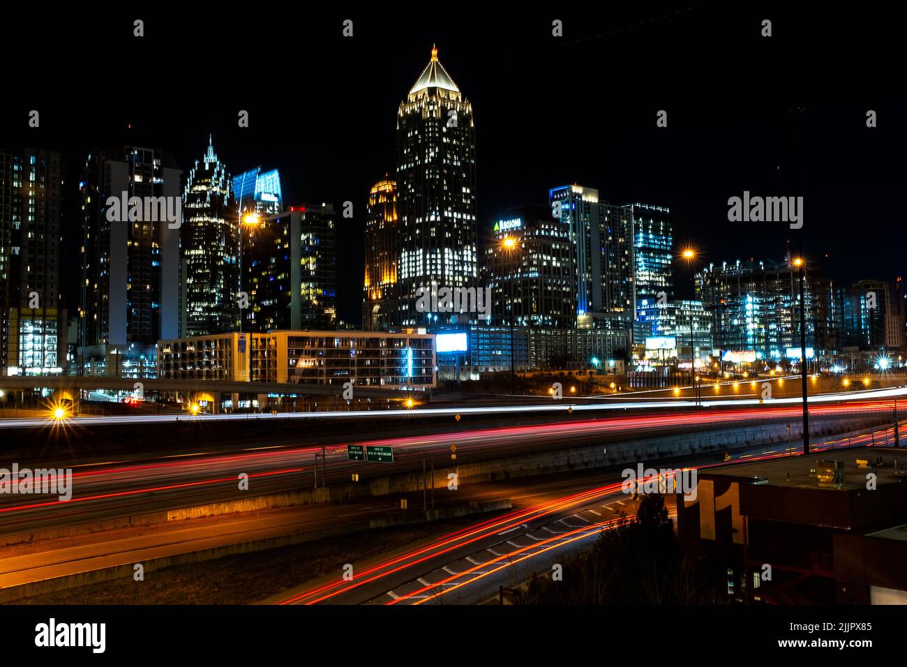 An aerial view of a highway against skyscrapers at night shot in long ...