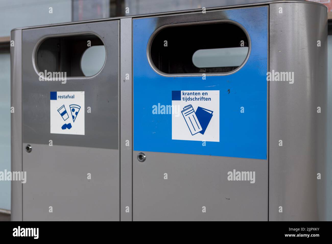 Waste bins on train station platform with separated trash cans. TRANSLATION: RESIDUAL WASTE ...