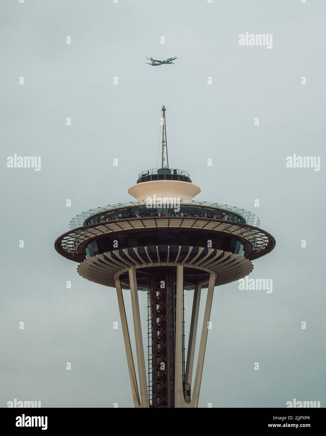 A plane flying over the Space Needle observation deck in Seattle ...