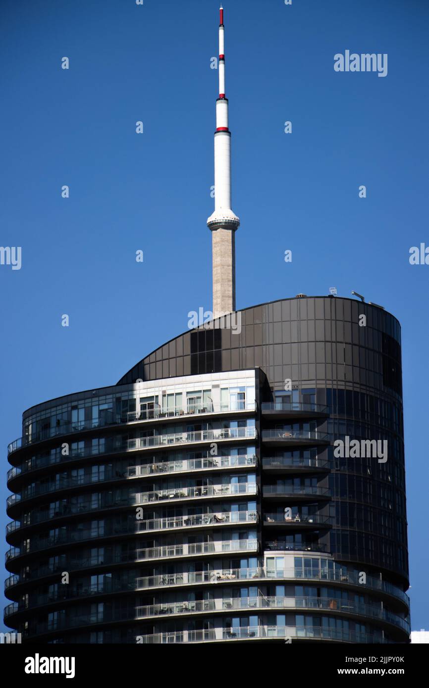 A high office building and the tip of CN Tower behind it in Toronto ...