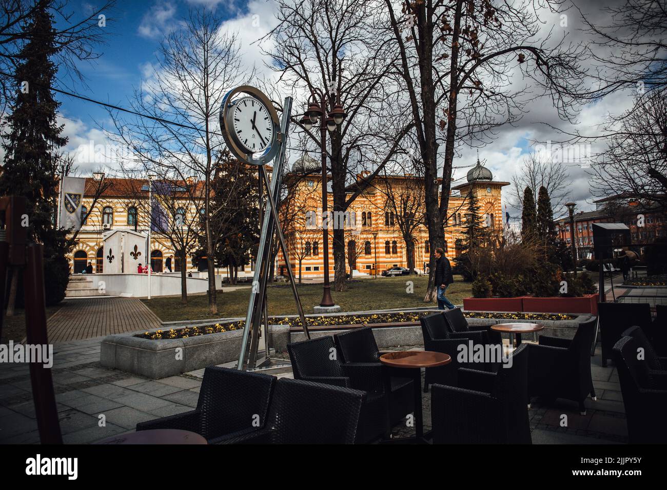 A beautiful view of the City hall and a cafe next to a city clock in ...