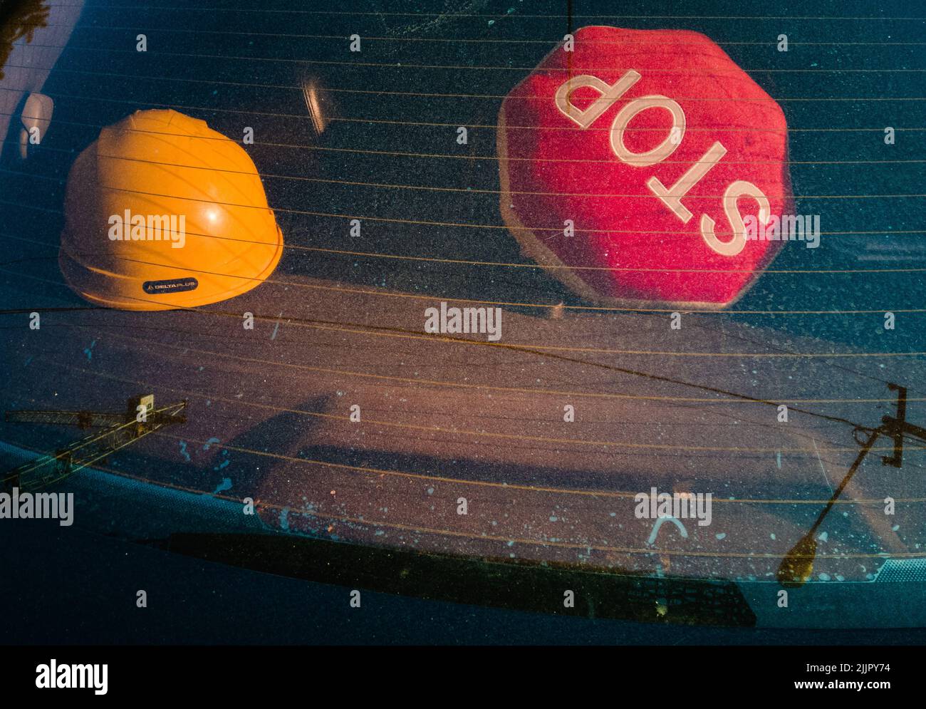 A stop sign pillow and a yellow helmet behind a car window Stock Photo ...