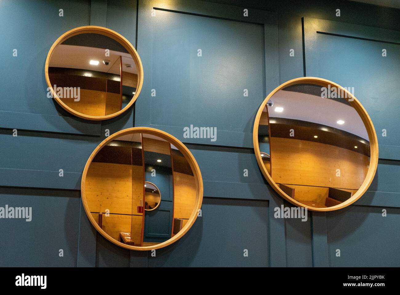 A three circular mirrors on a blue wall inside building on Lisbon ...