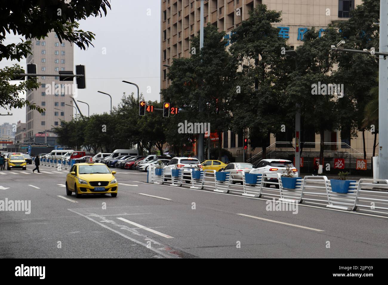 A view of a street in Chongqing, China with traditional yellow taxi and ...