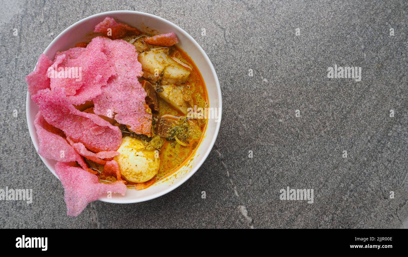 A top view of a portion of traditional Indonesian lontong sayur meal on ...