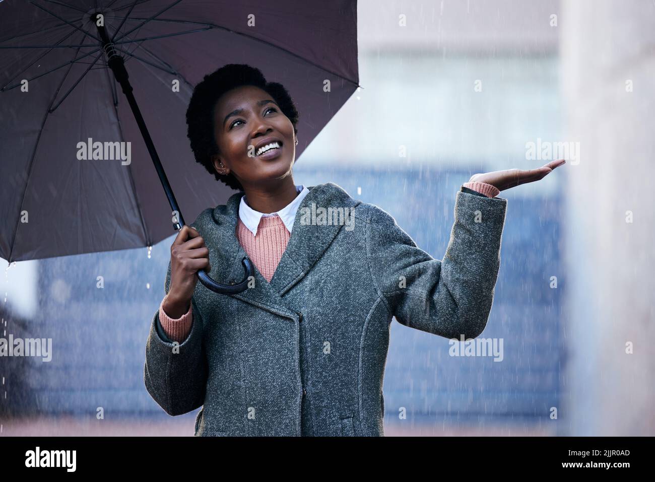 The rain wont stop me from moving forward. a young businesswoman using ...