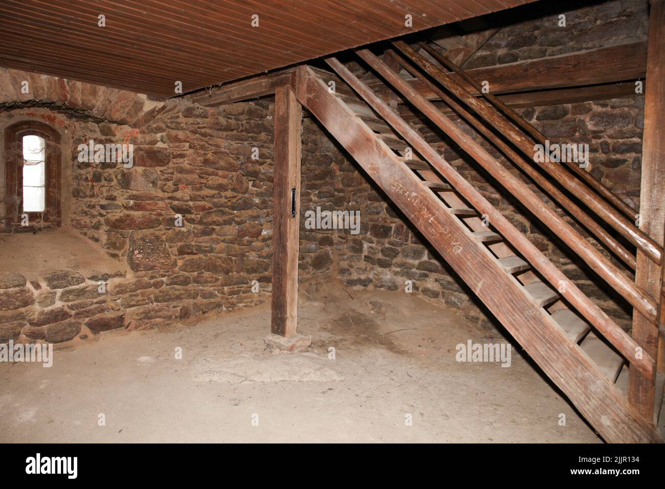 The wooden steps inside an empty building room with stone walls Stock ...