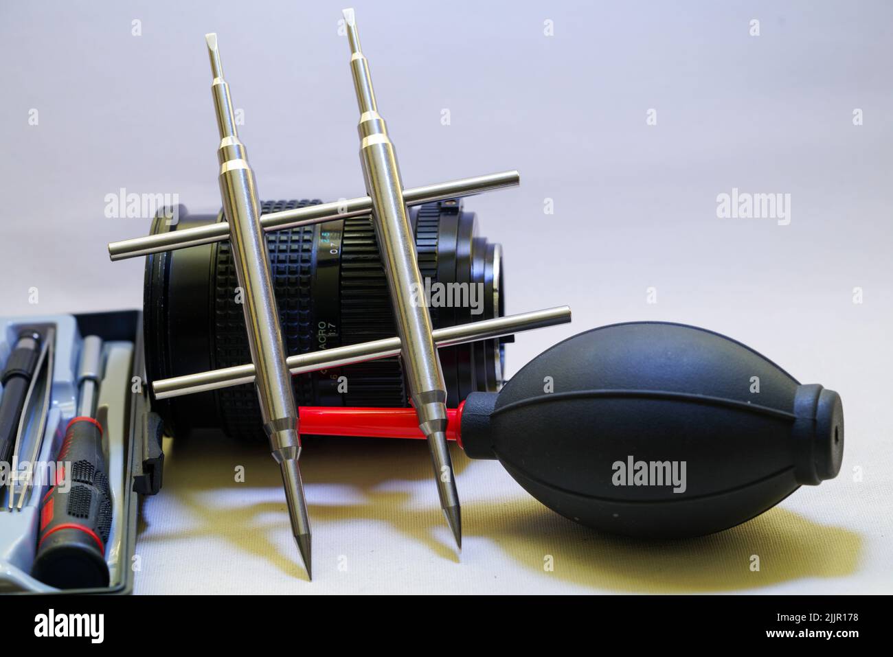 The disassembled lens from the camera and screwdriver isolated on a ...