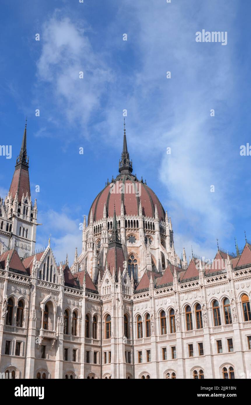 A vertical shot of the Hungarian Parliament Building on blue cloudy sky ...