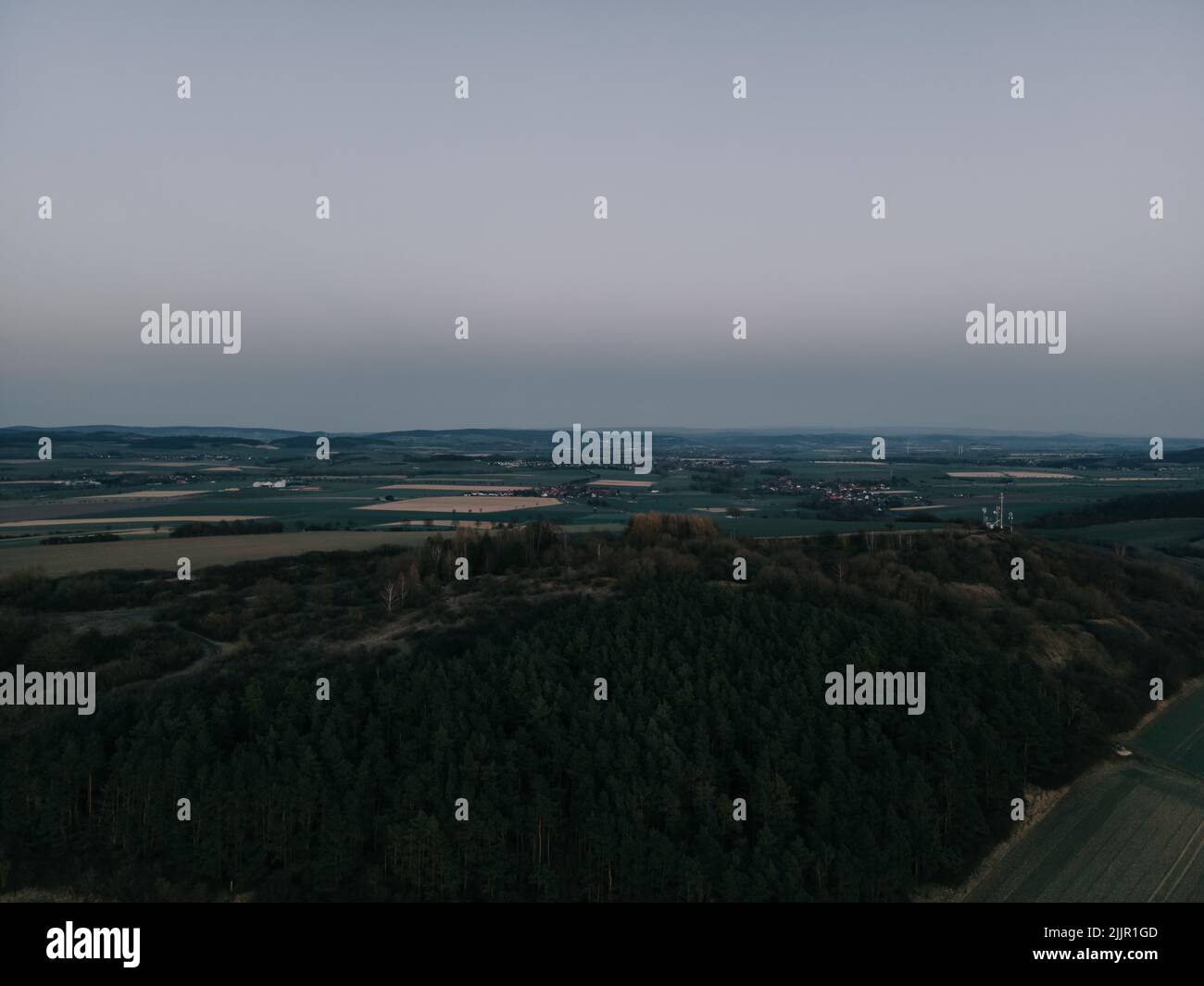 An aerial view of a rural area with mountain forests on clear sky ...